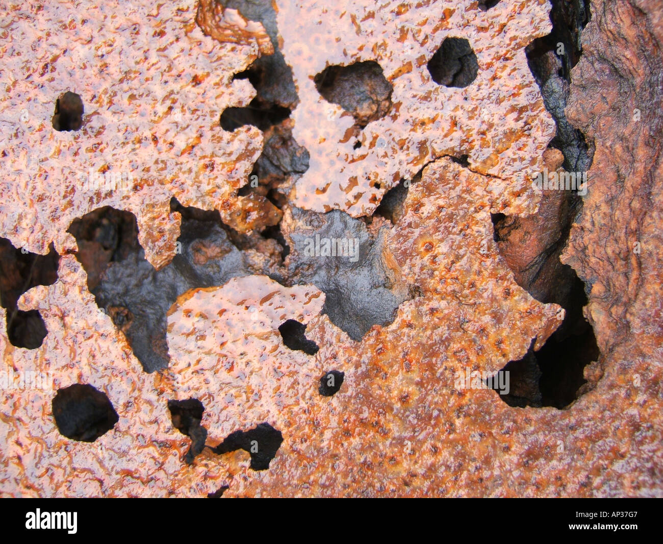 corroded piece of metal full of holes on derelict industrial site Stock ...