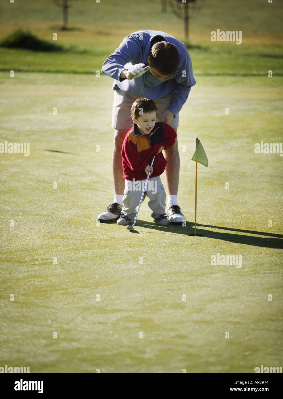 Father and son practice golf Stock Photo - Alamy