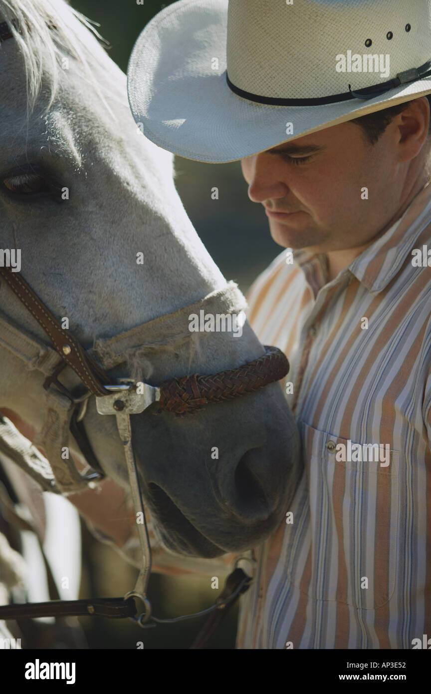 Cowboy next to a horse Stock Photo - Alamy