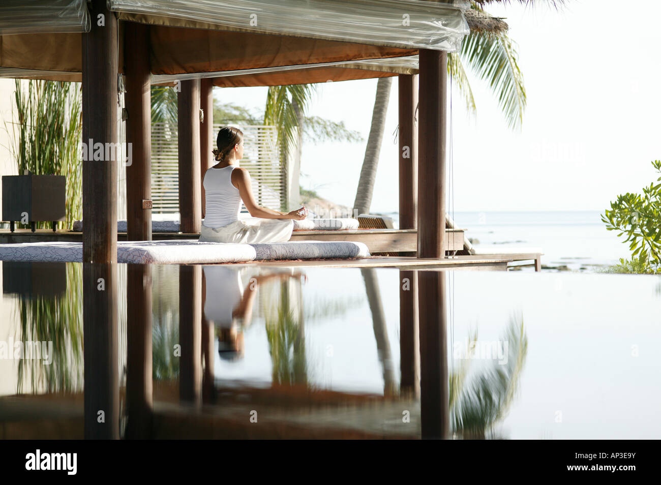 Woman meditating by a pool, Reflection in the water, Relaxation ...