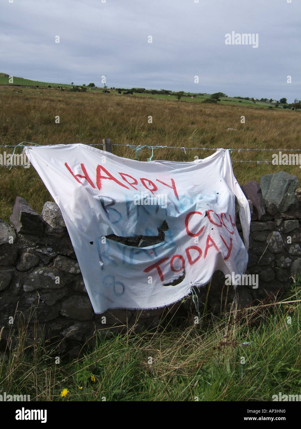 a surprise happy birthday message on road side fence Stock Photo - Alamy