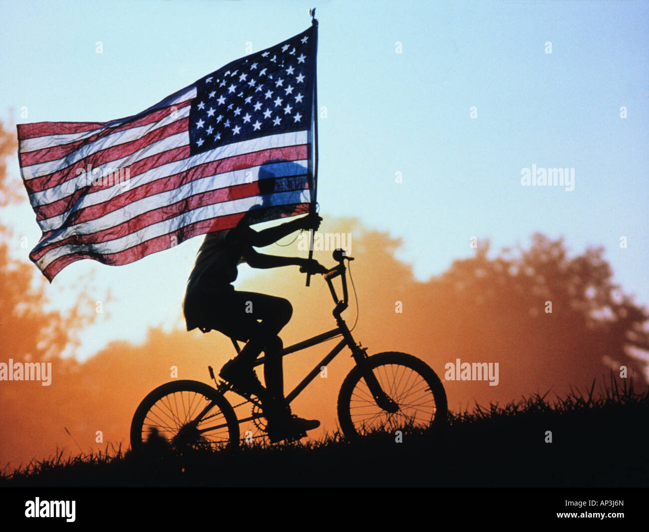 Boy on bike with American flag Stock Photo - Alamy