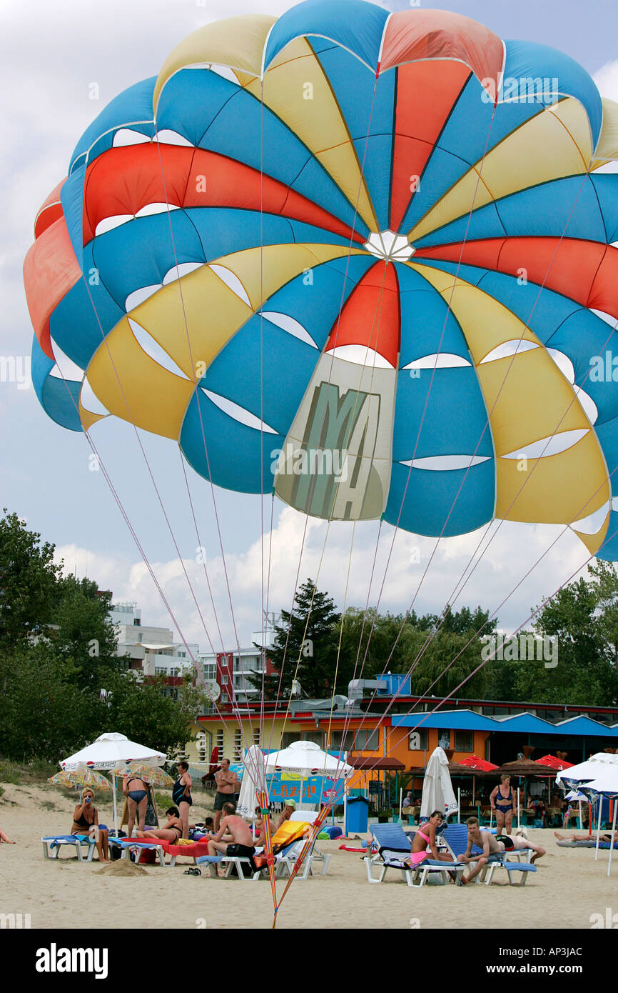 parachute paragliding behind a beach parasailing rainbow red yellow ...
