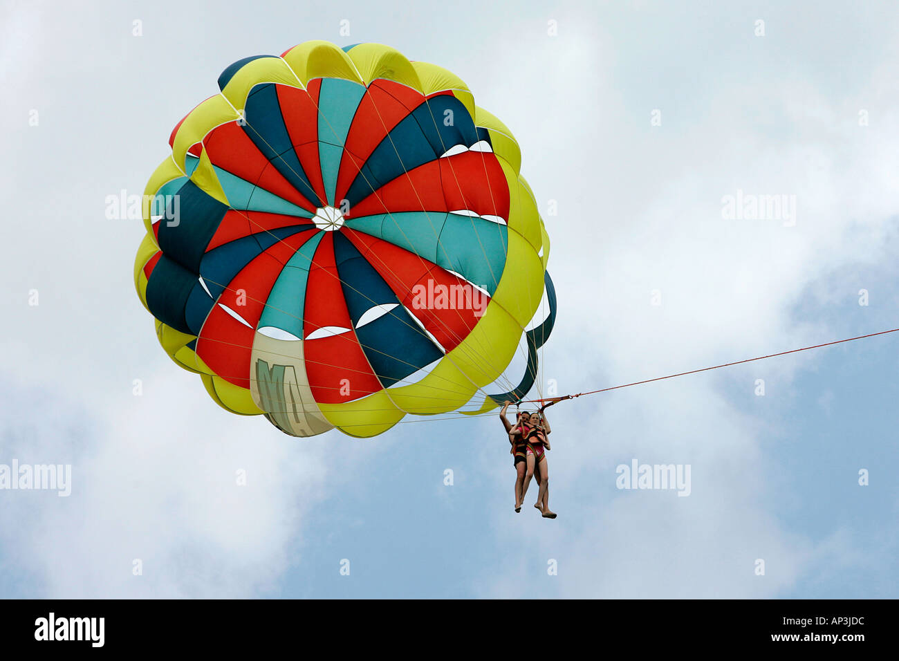 parachute paragliding behind a beach parasailing rainbow red yellow ...