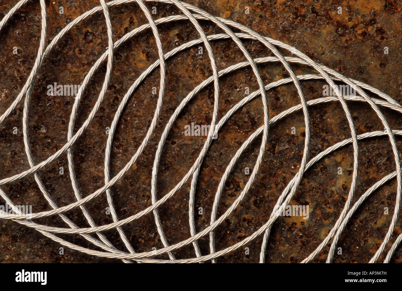 Coil of steel cable on rusty surface Stock Photo - Alamy