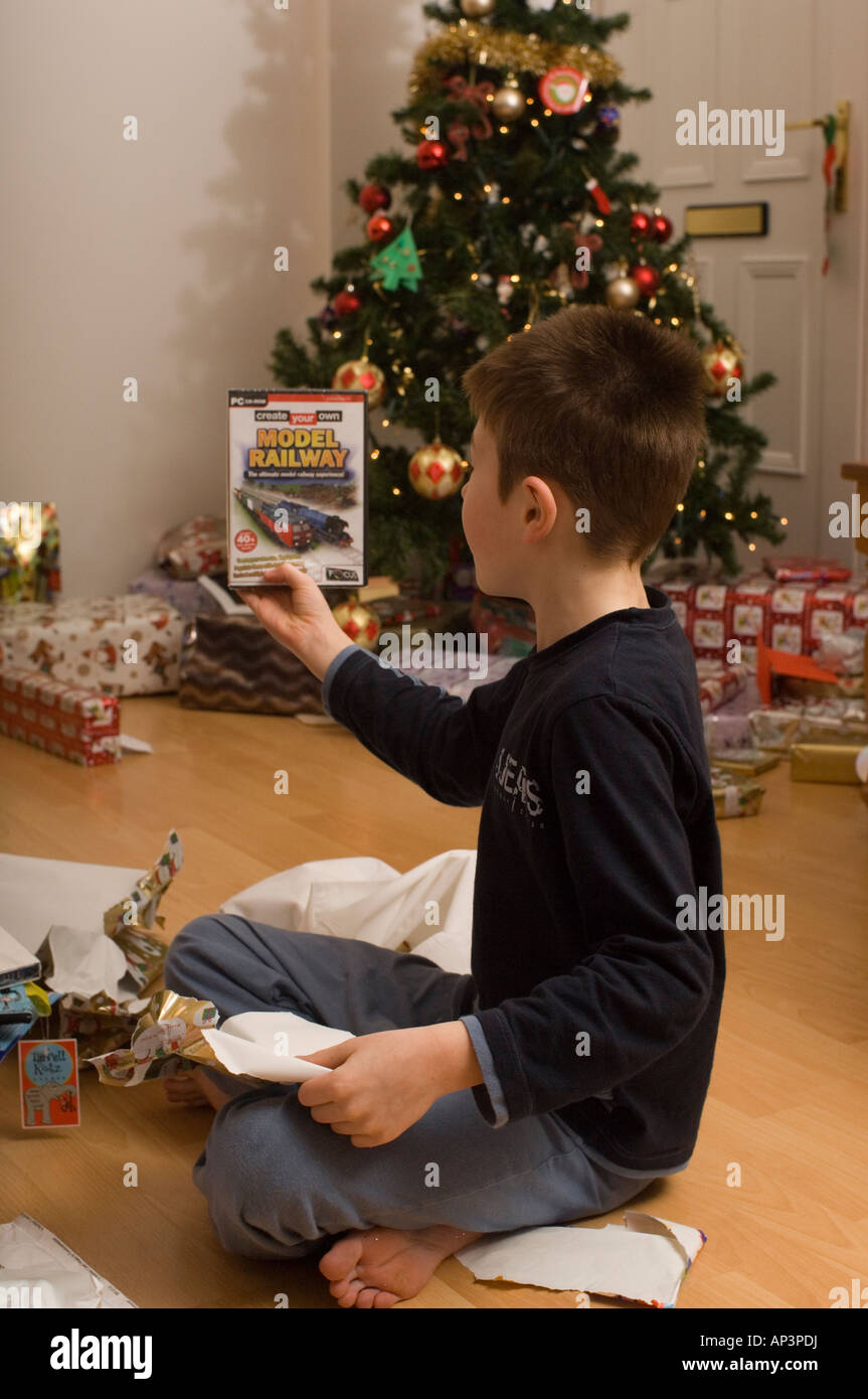 Children unwrapping presents under the christmas tree hi-res stock ...