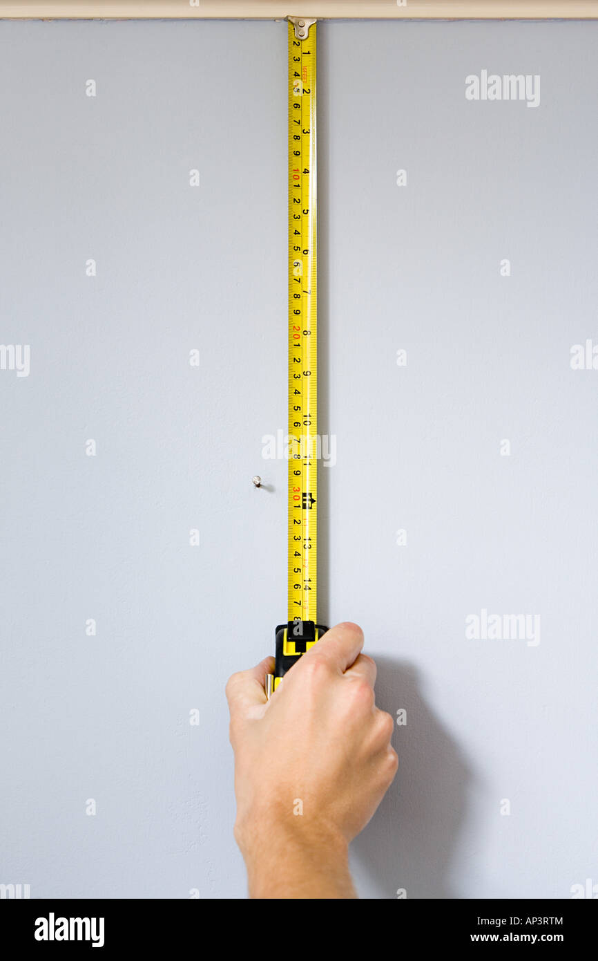 Person measuring wall Stock Photo - Alamy