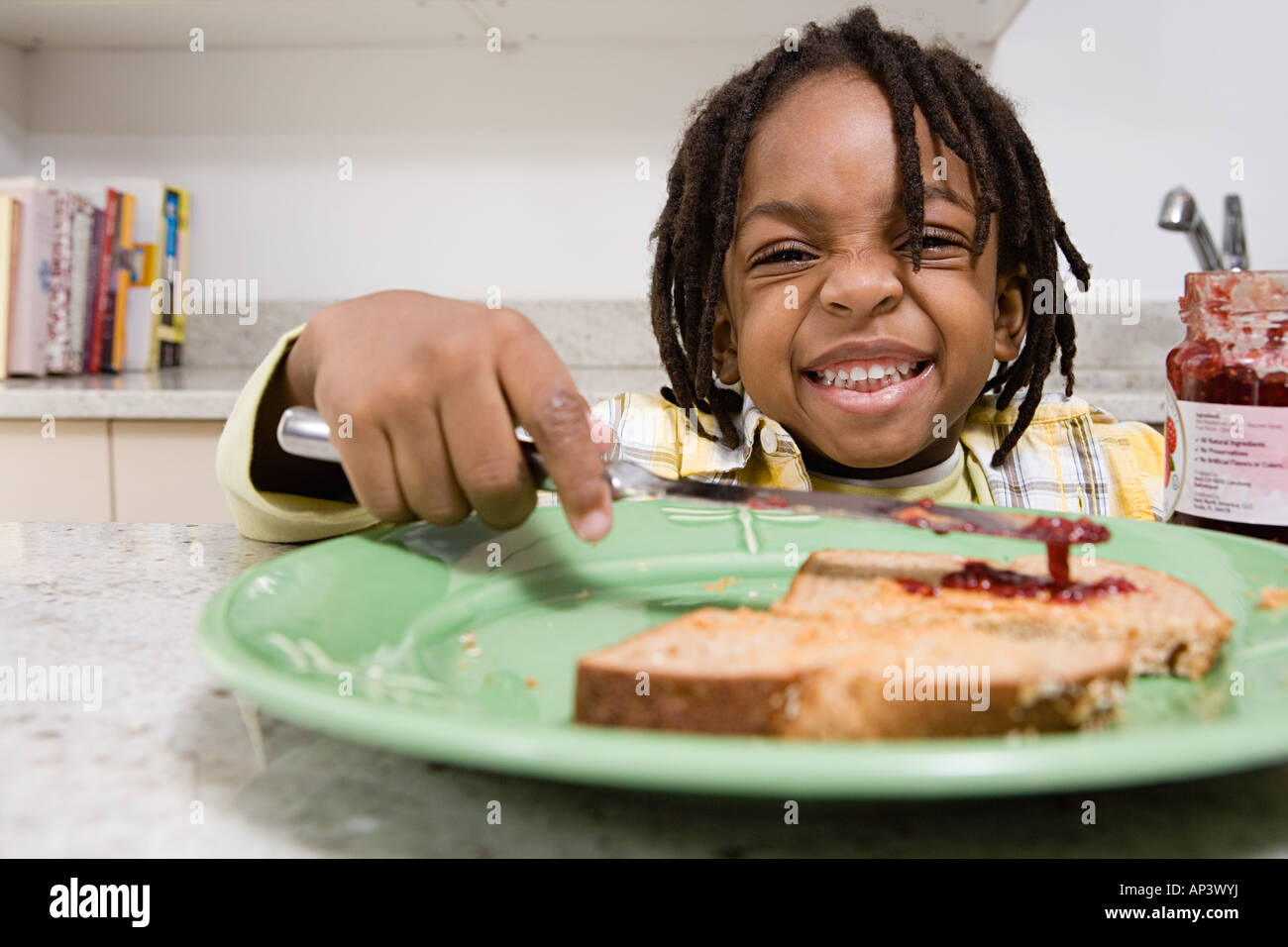Boy spreading jam on toast Stock Photo - Alamy