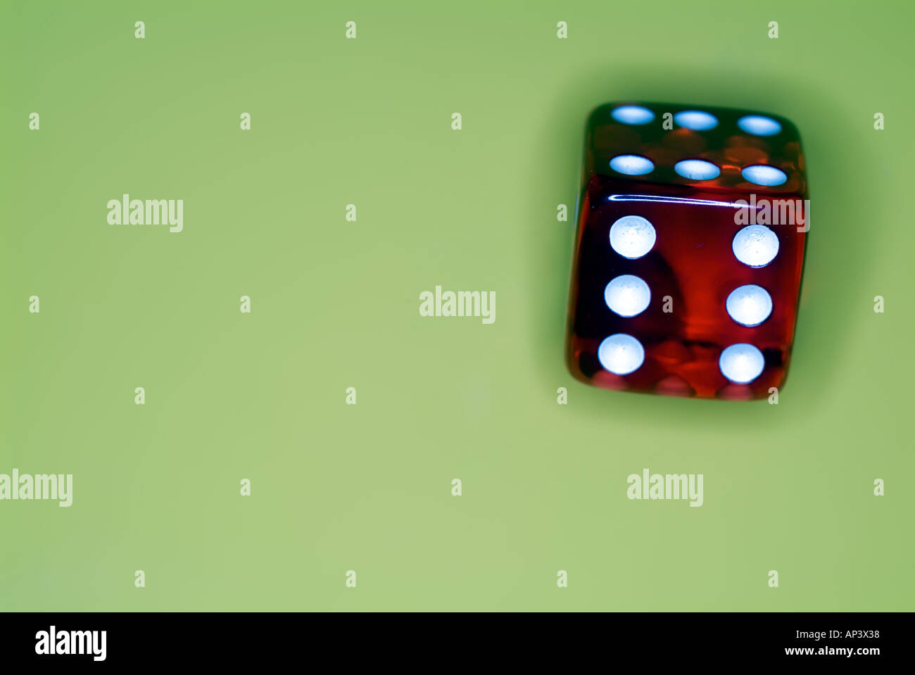 red loaded die on green background Stock Photo - Alamy