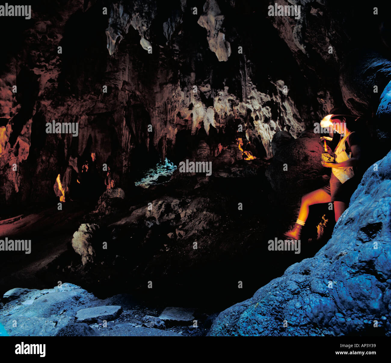 A female cave explorer is dusting a fossil in Callao Caves in ...