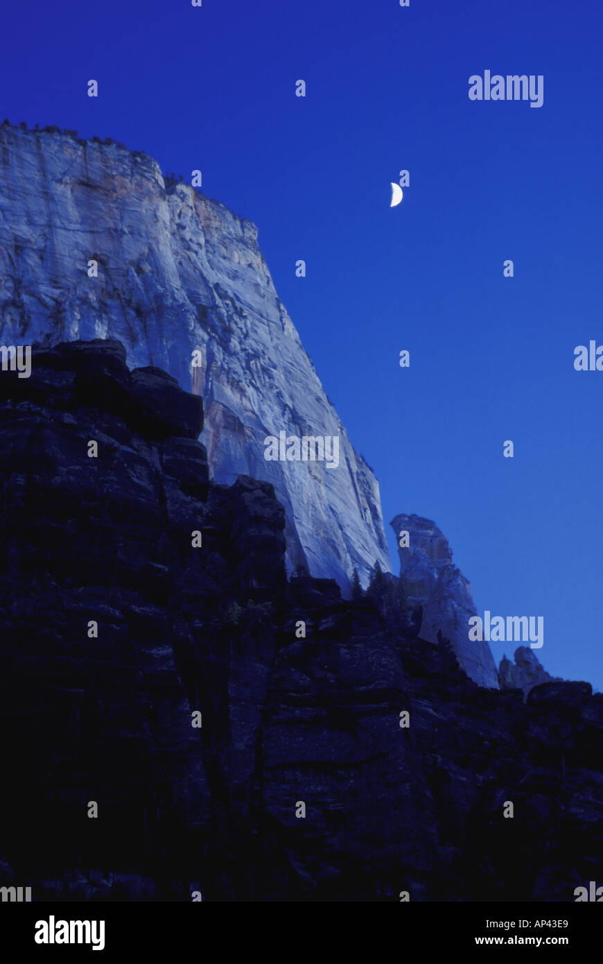 Mountain cliff with deep blue sky and quarter moon Stock Photo - Alamy