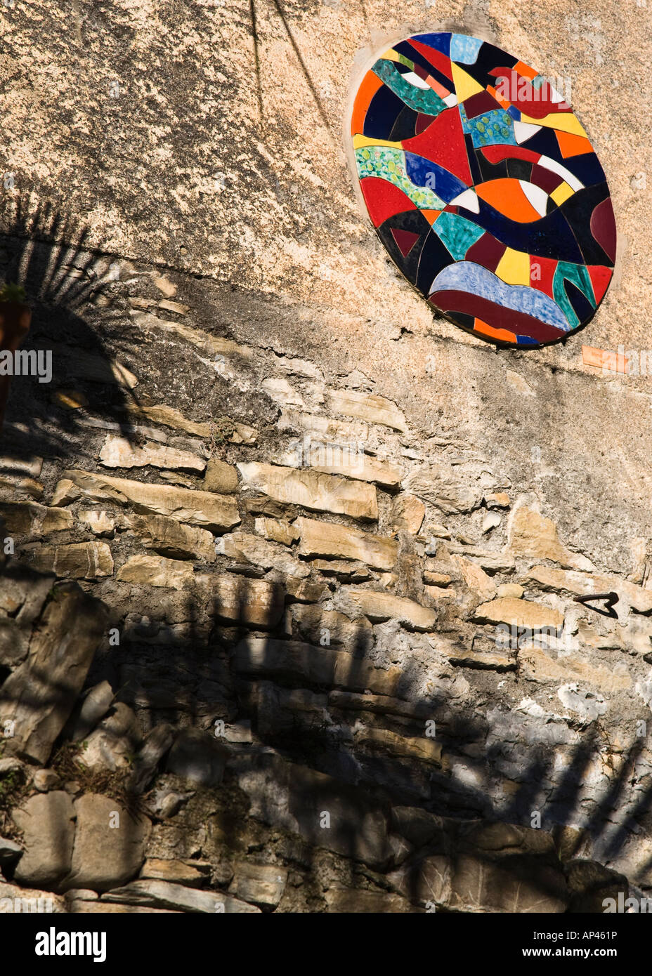 A circular collage made from different shaped pieces of coloured tiles ...