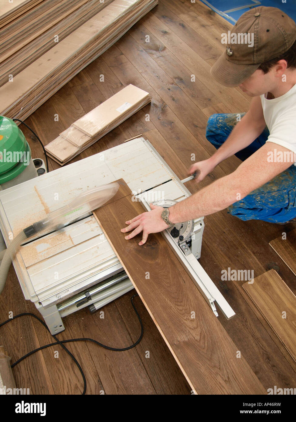 Man using circular saw table when laying new wooden parquet floor in a ...