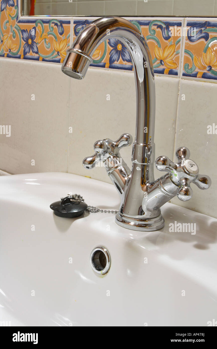 Sink faucet with white tiles Stock Photo - Alamy