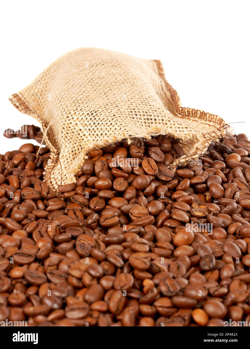 Burlap sack with coffee beans spilling out over a white background ...