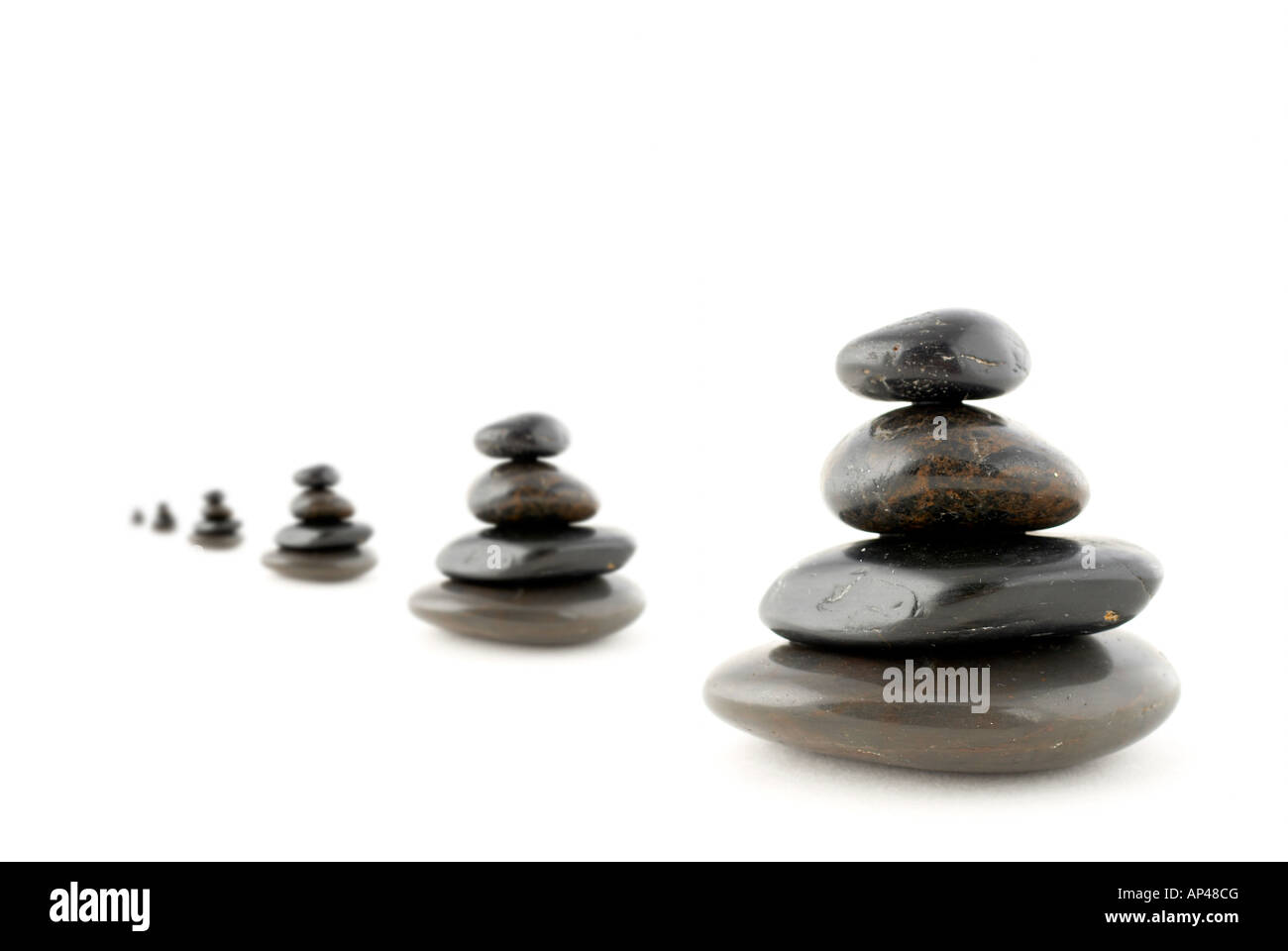Stacks of balanced stones with shadow on white background Very shallow ...