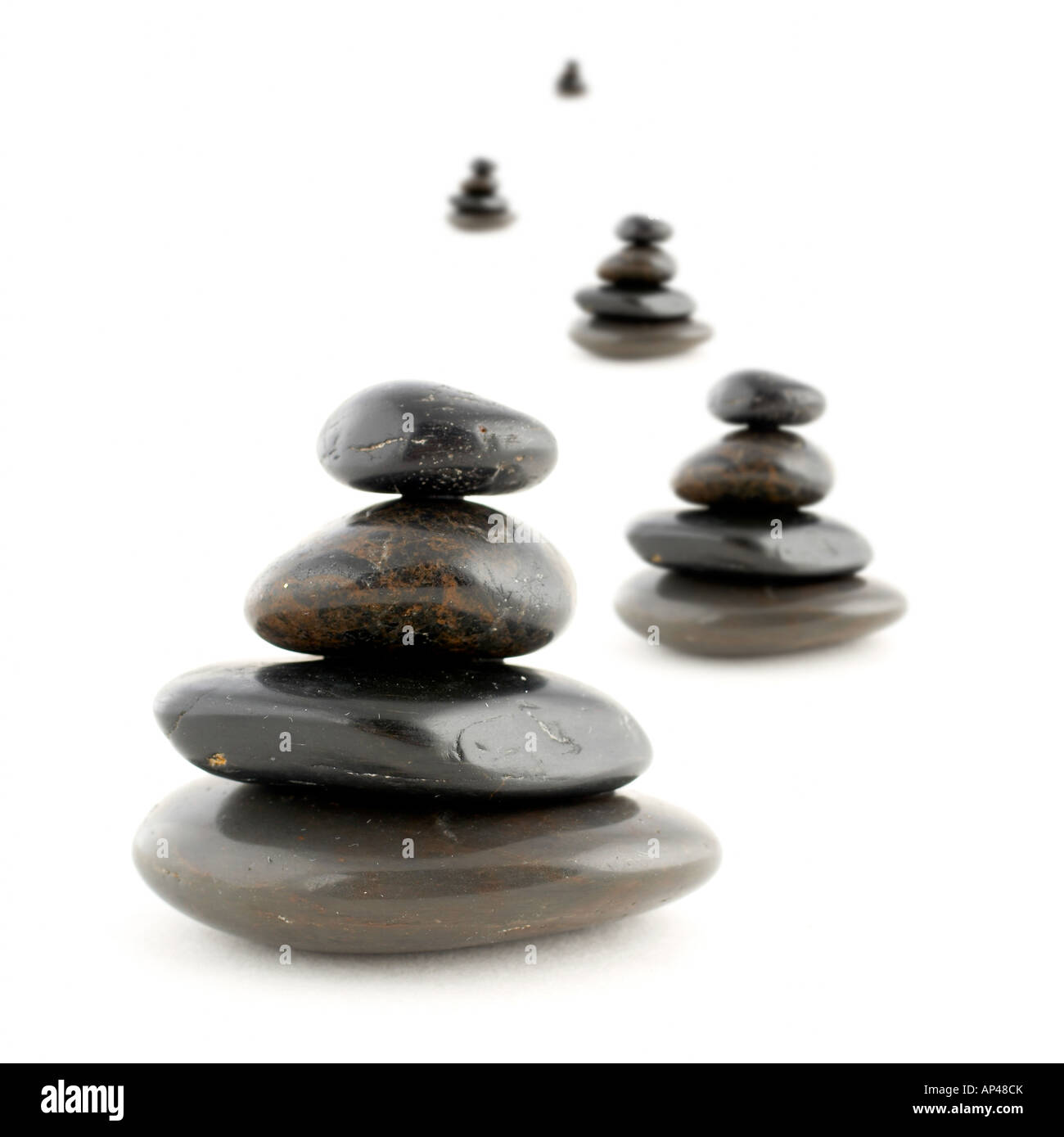 Stacks of balanced stones with shadow on white background Very shallow ...