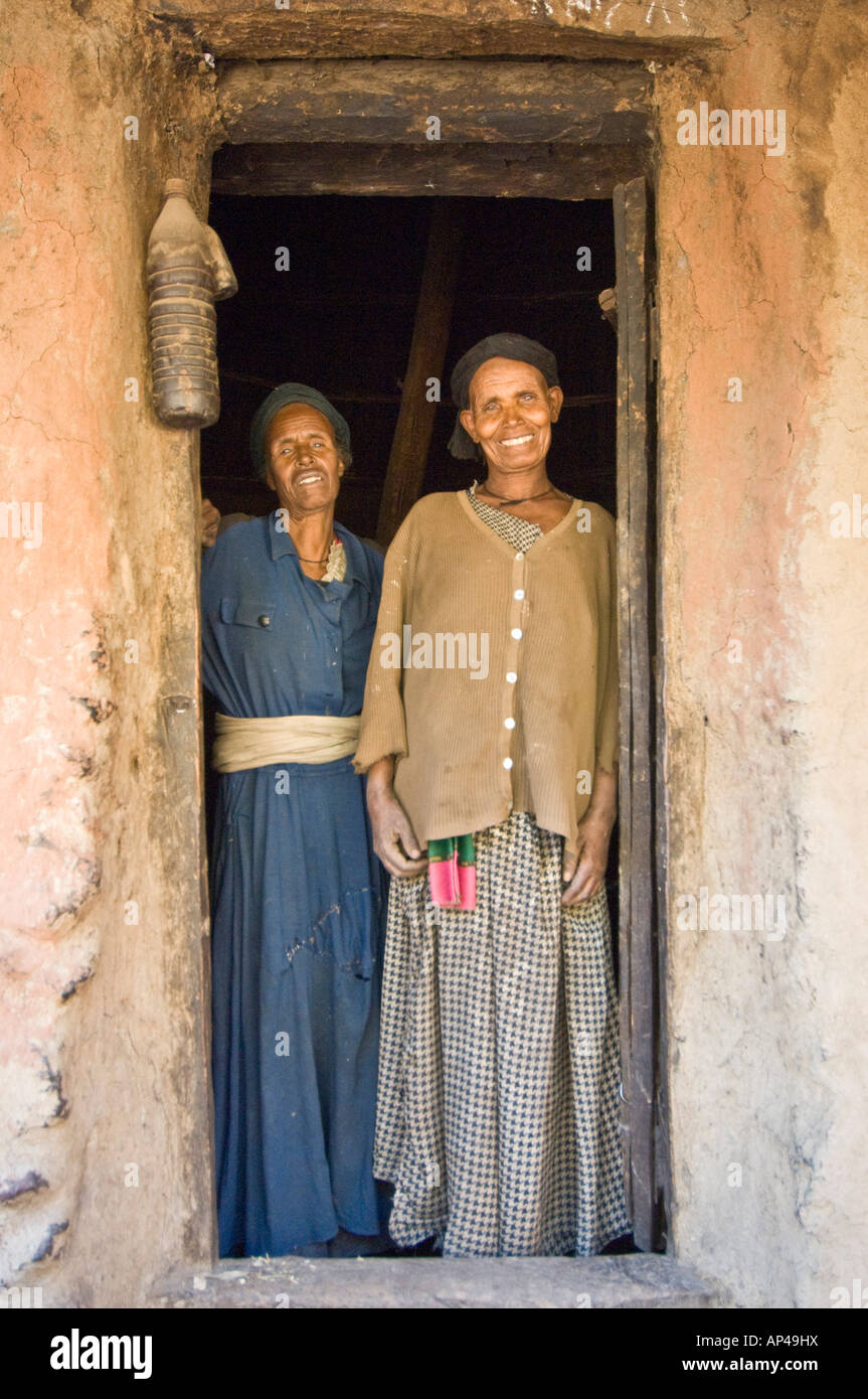 Two poor elderly local woman at the doorway of their home in Lalibela ...