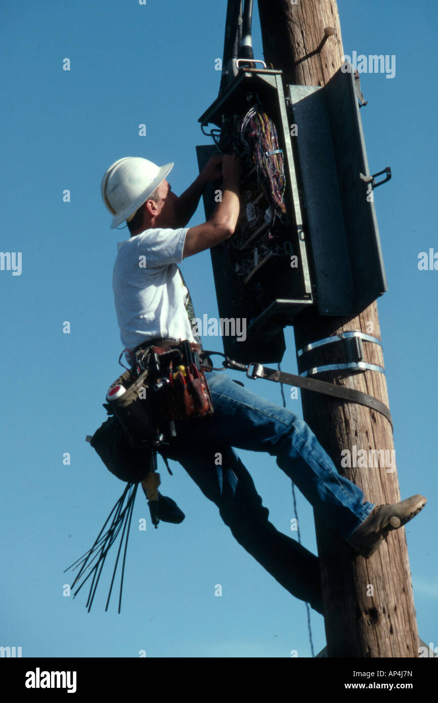 A telephone repair person works atop a telephone pole Stock Photo - Alamy