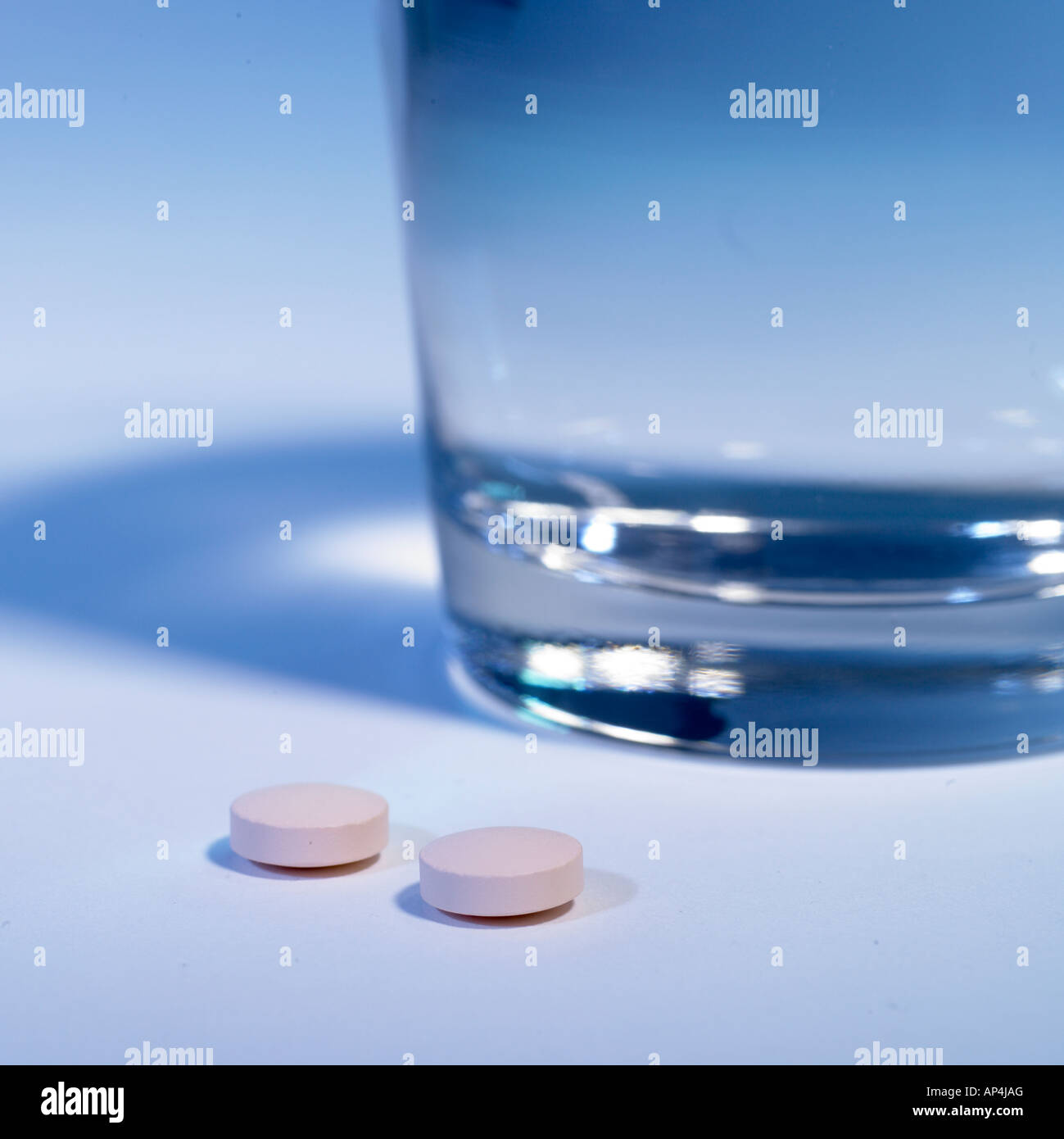 Glass of water with 2 pills Stock Photo - Alamy