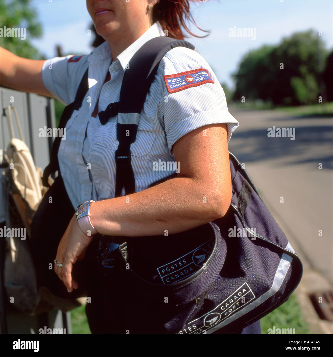 A Canadian post office woman female postal worker delivering mail ...