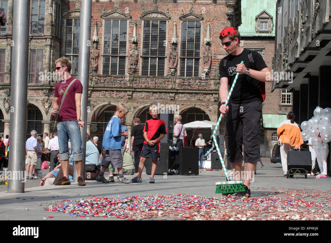 Marketplace in Bremen Germany. Man sweeping the caps Stock Photo - Alamy