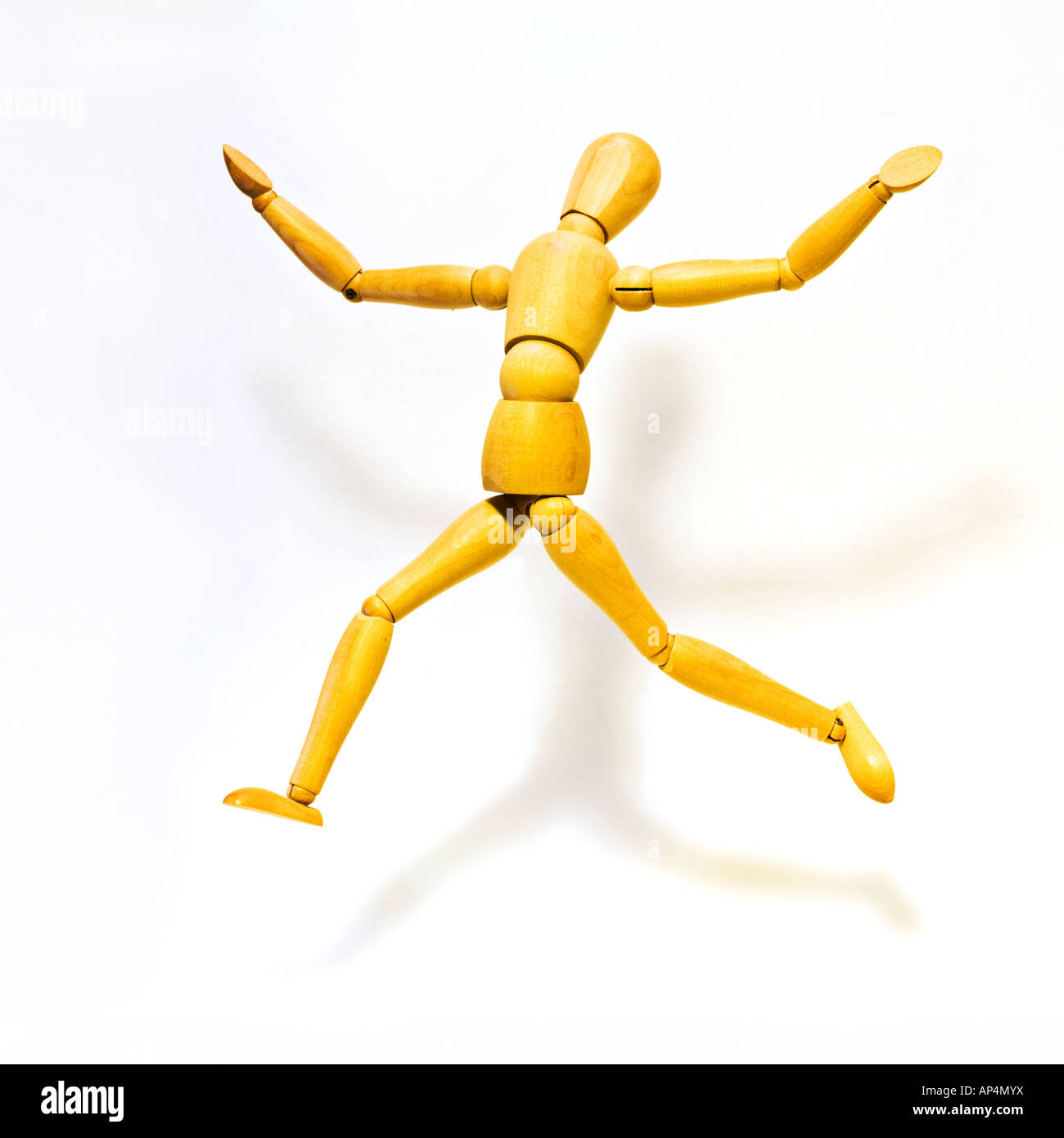 Wooden manikin jumping for joy across a stark white background Stock ...