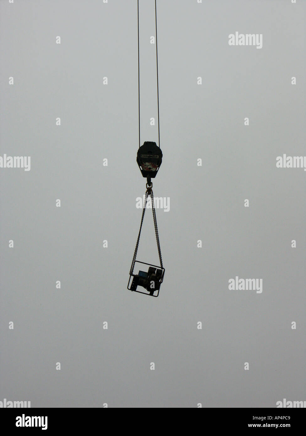 Crane working near Multistorey Flats lifting a portable generator into ...