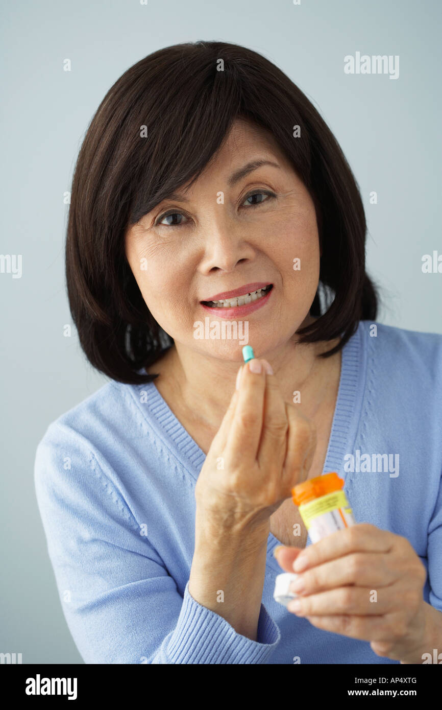 Senior Asian woman taking medication Stock Photo - Alamy