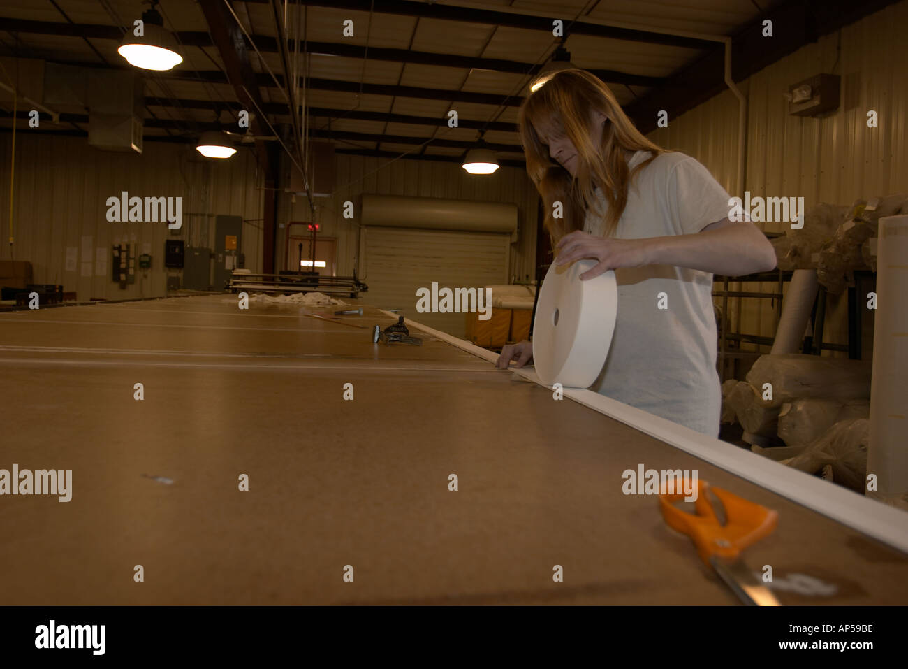 Female inmate laying out fabric for cutting in the sewing program one ...