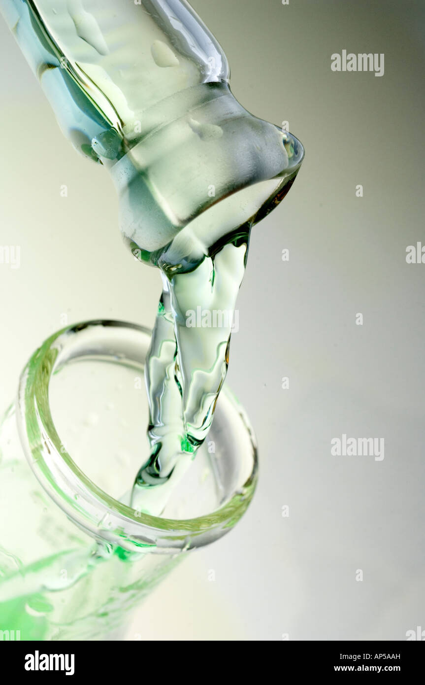 Pouring green liquid into lab flask Stock Photo - Alamy