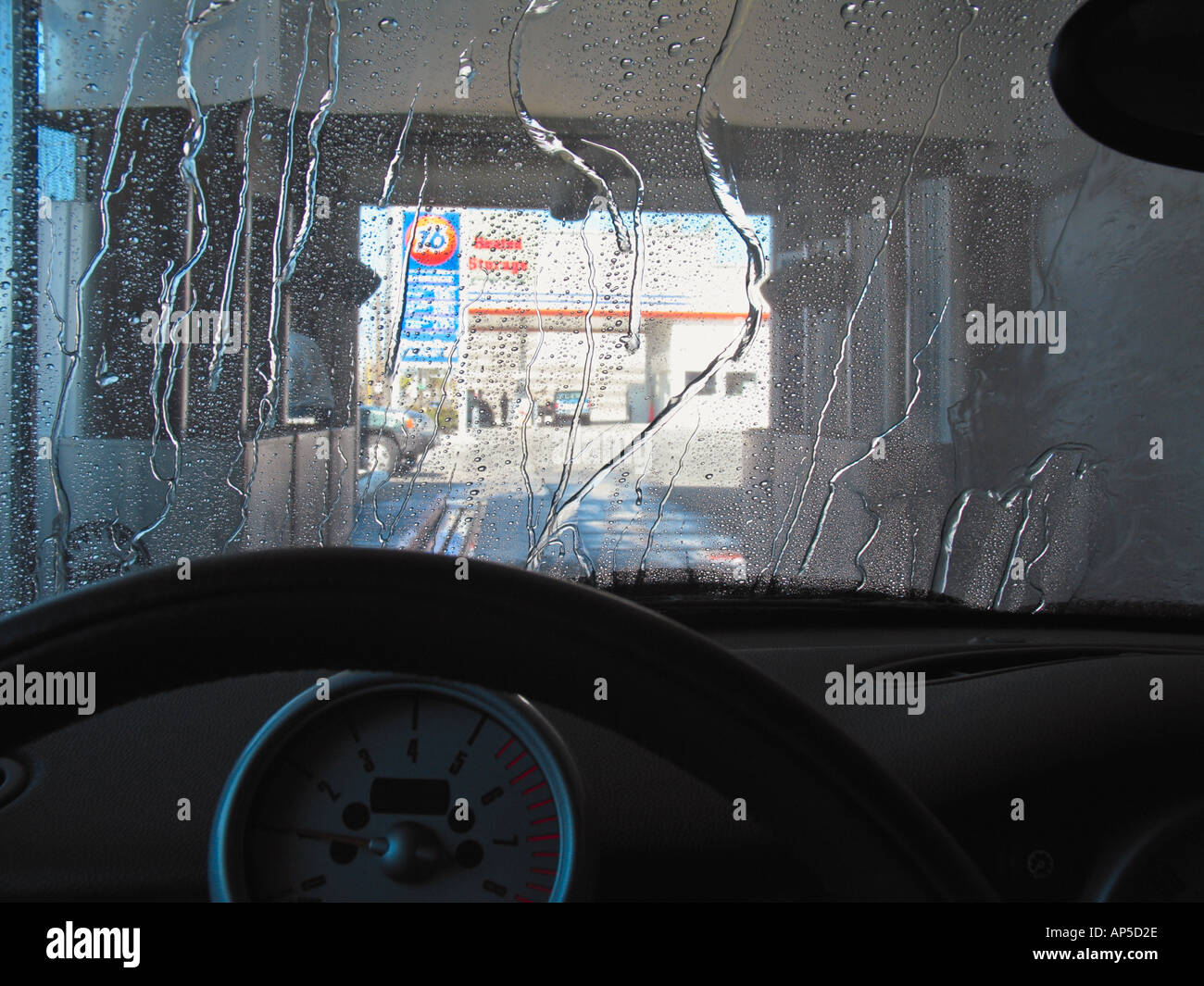 Streams of water running down windshield of car going through automatic ...