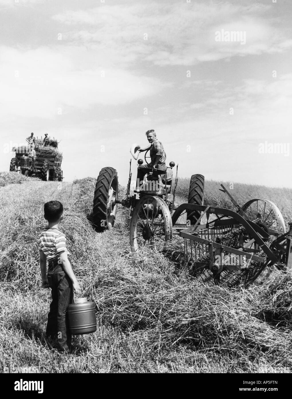 Young boy brings water to his father who is working the farm fields on ...