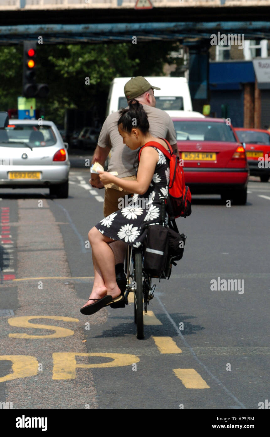 A girl riding a book on bikecycle London England 08 08 2004 Stock Photo ...