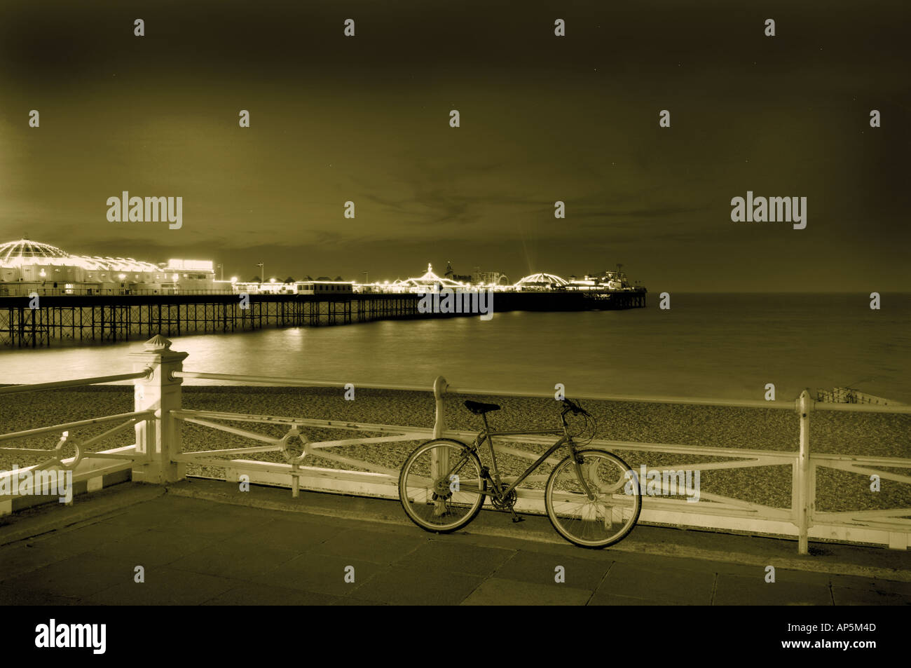 Bicycle on railings with Brighton Pier East Sussex UK in the background ...