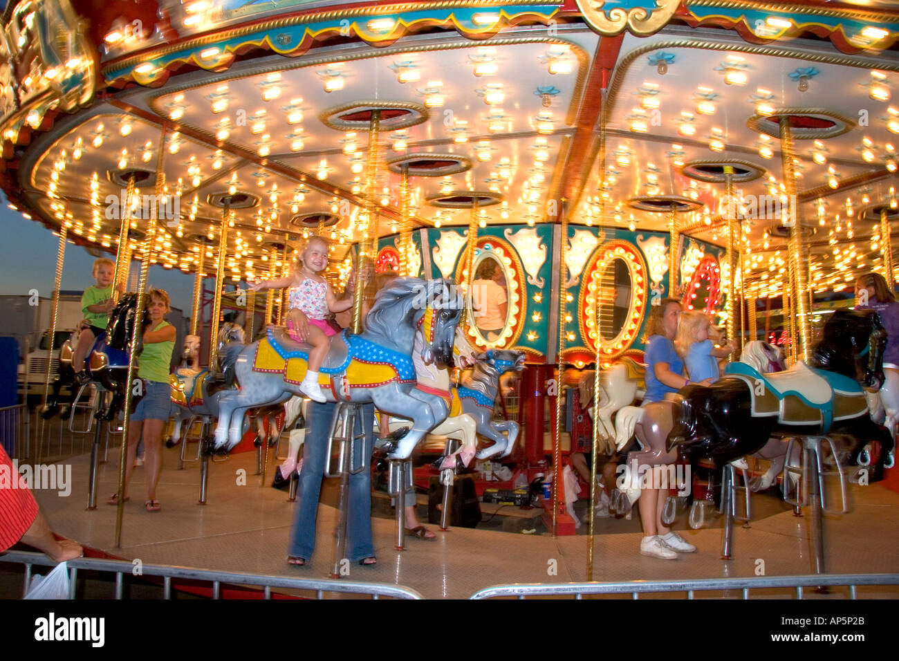 Children and adults ride a carousel at the Iowa state fair in Des ...