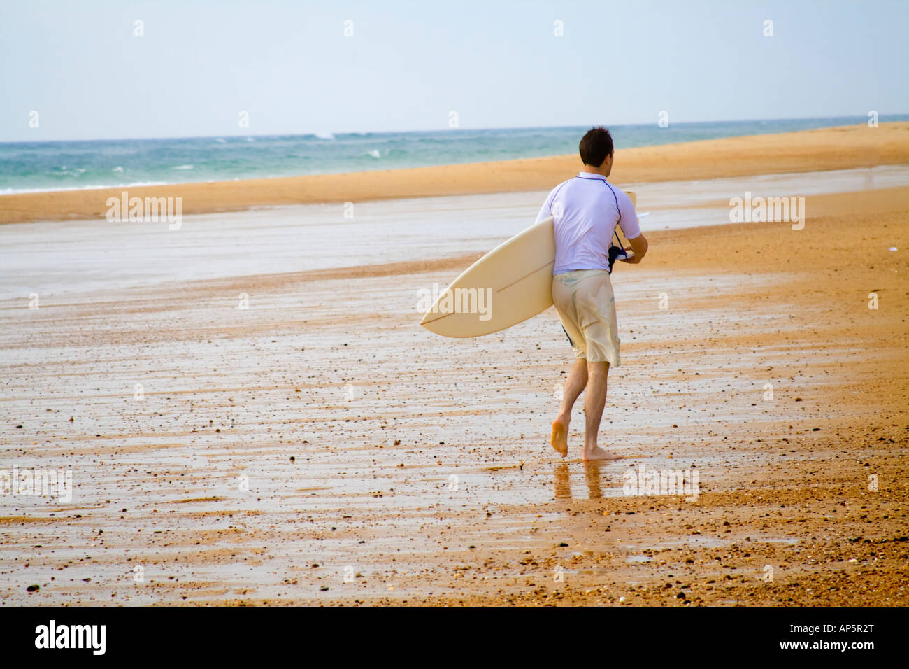 Surfer walking on the beach. Horizontal shot Stock Photo - Alamy