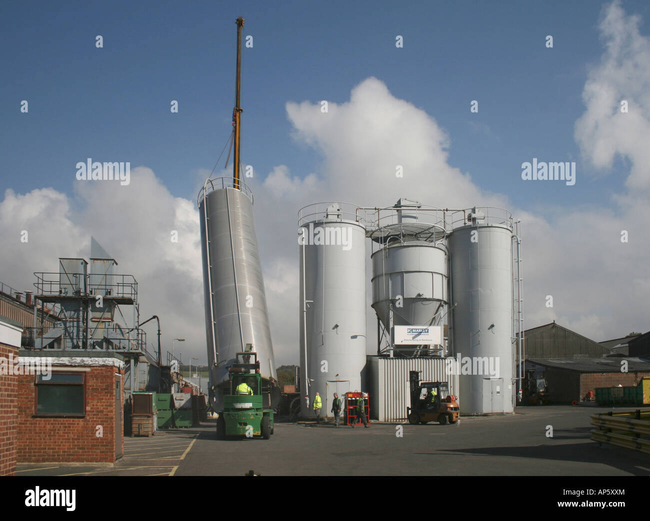 One of a set of 4 large storage silos being lifted by crane prior to ...