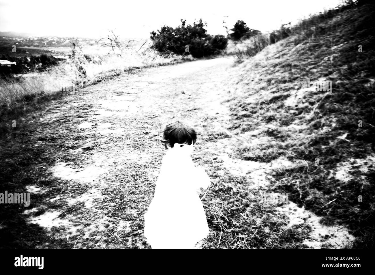 Girl walking off path with twisted old trees Stock Photo - Alamy