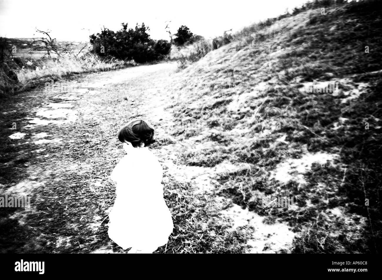 Girl walking off path with twisted old trees Stock Photo - Alamy
