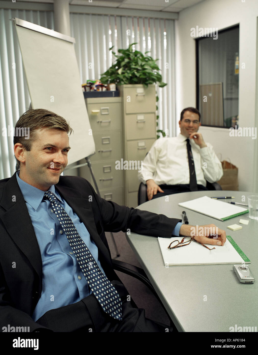Two business men at table meeting and taking notes with presentation ...