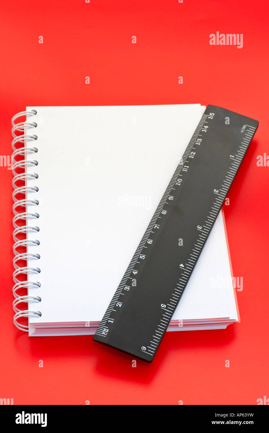 White notebook and measure on red background Stock Photo - Alamy