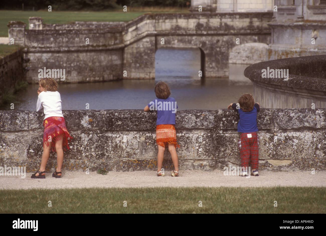 children sightseeing on holiday in Europe, looking at the moat of a ...