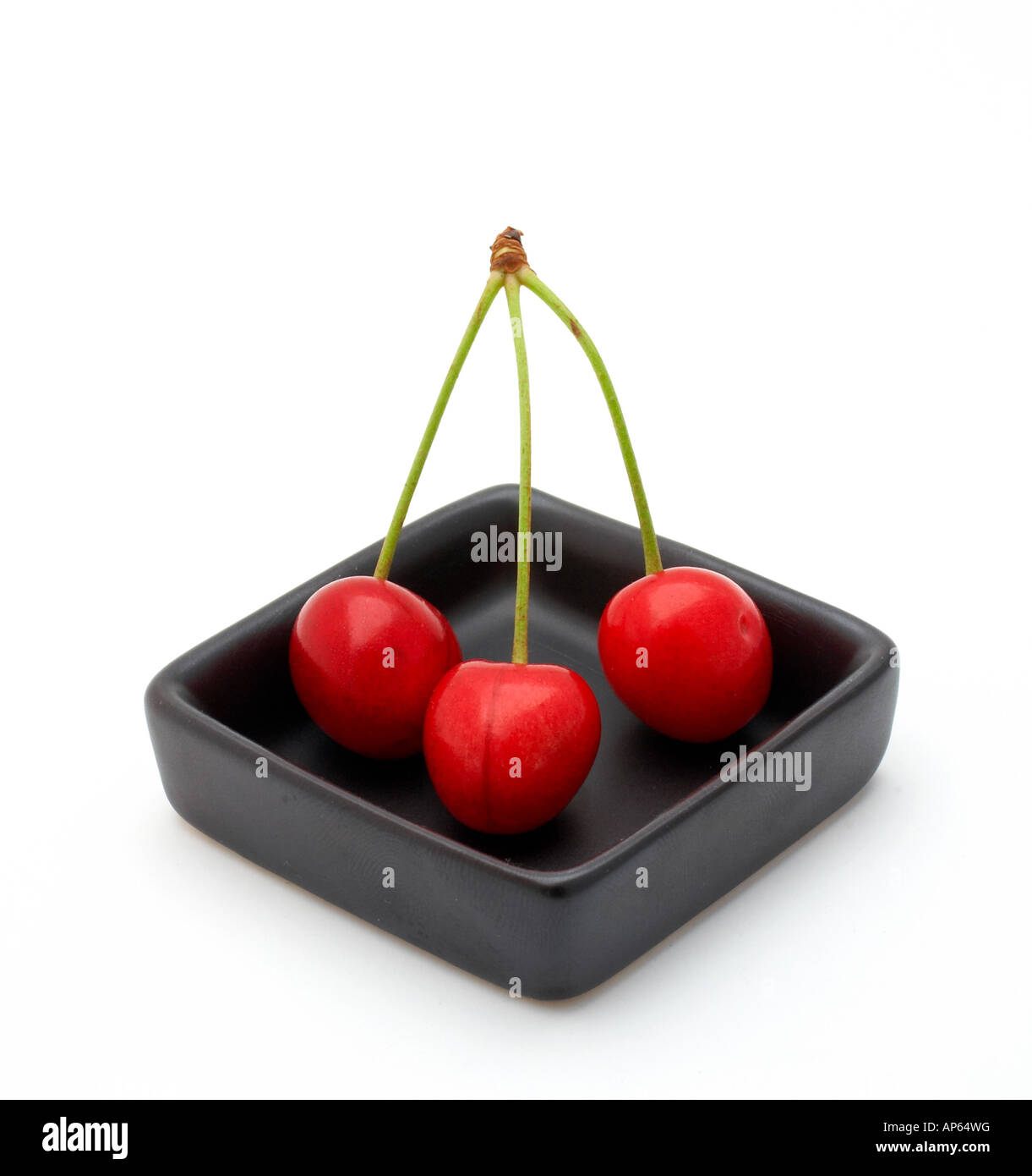 Three cherries in a black bowl isolated on white background Stock Photo ...