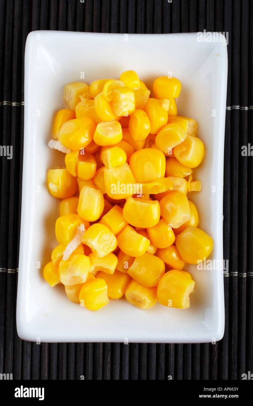 Sweetcorn inside the white dish on bamboo mat Stock Photo - Alamy