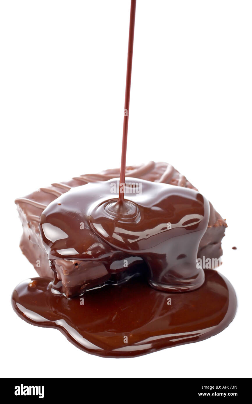 Chocolate syrup being poured over a cake on white background Stock ...