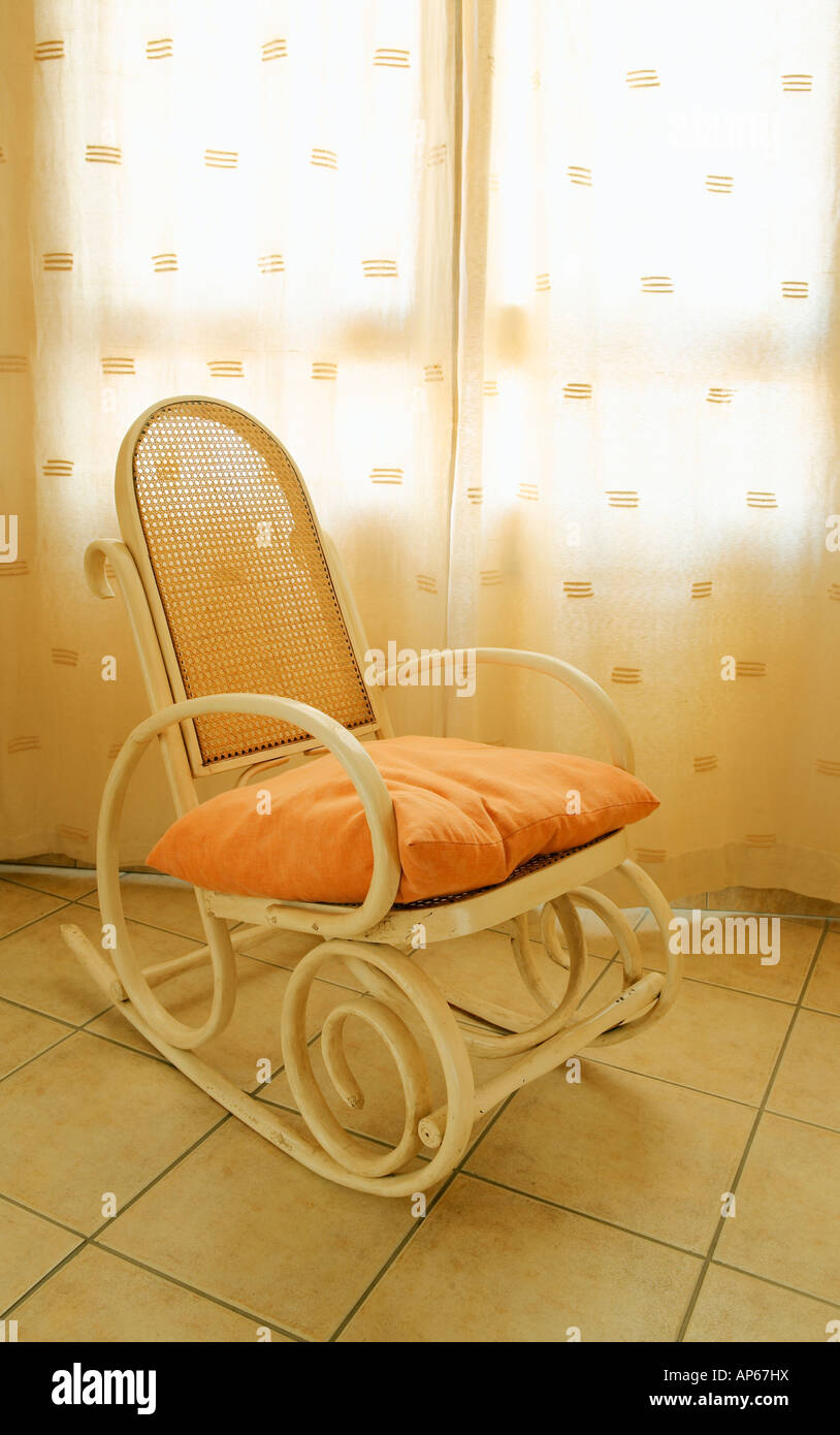 Antique wooden rocking chair near the window illuminated by the spring ...