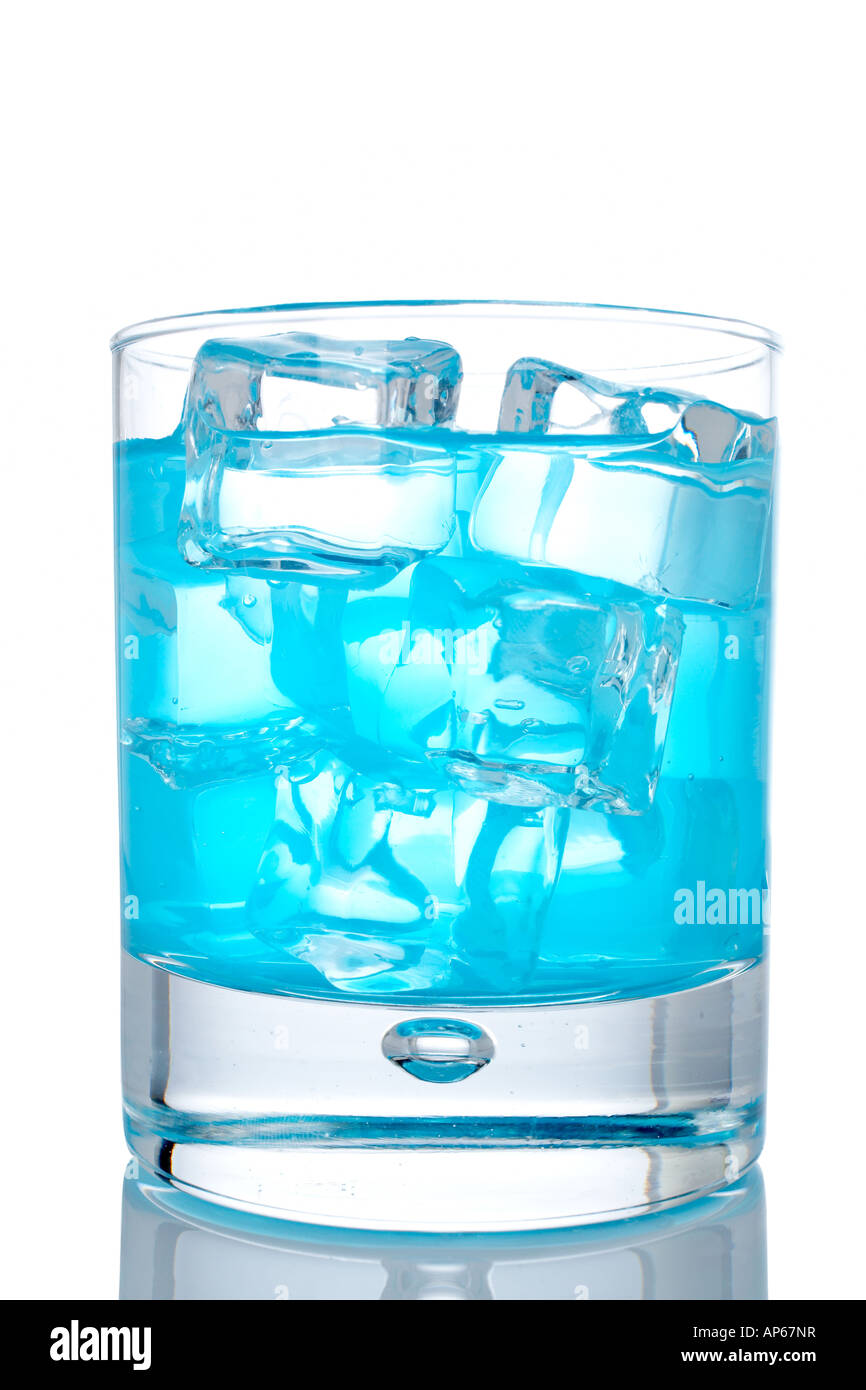 Glass of blue paradise cocktail with ice cubes reflected on white ...