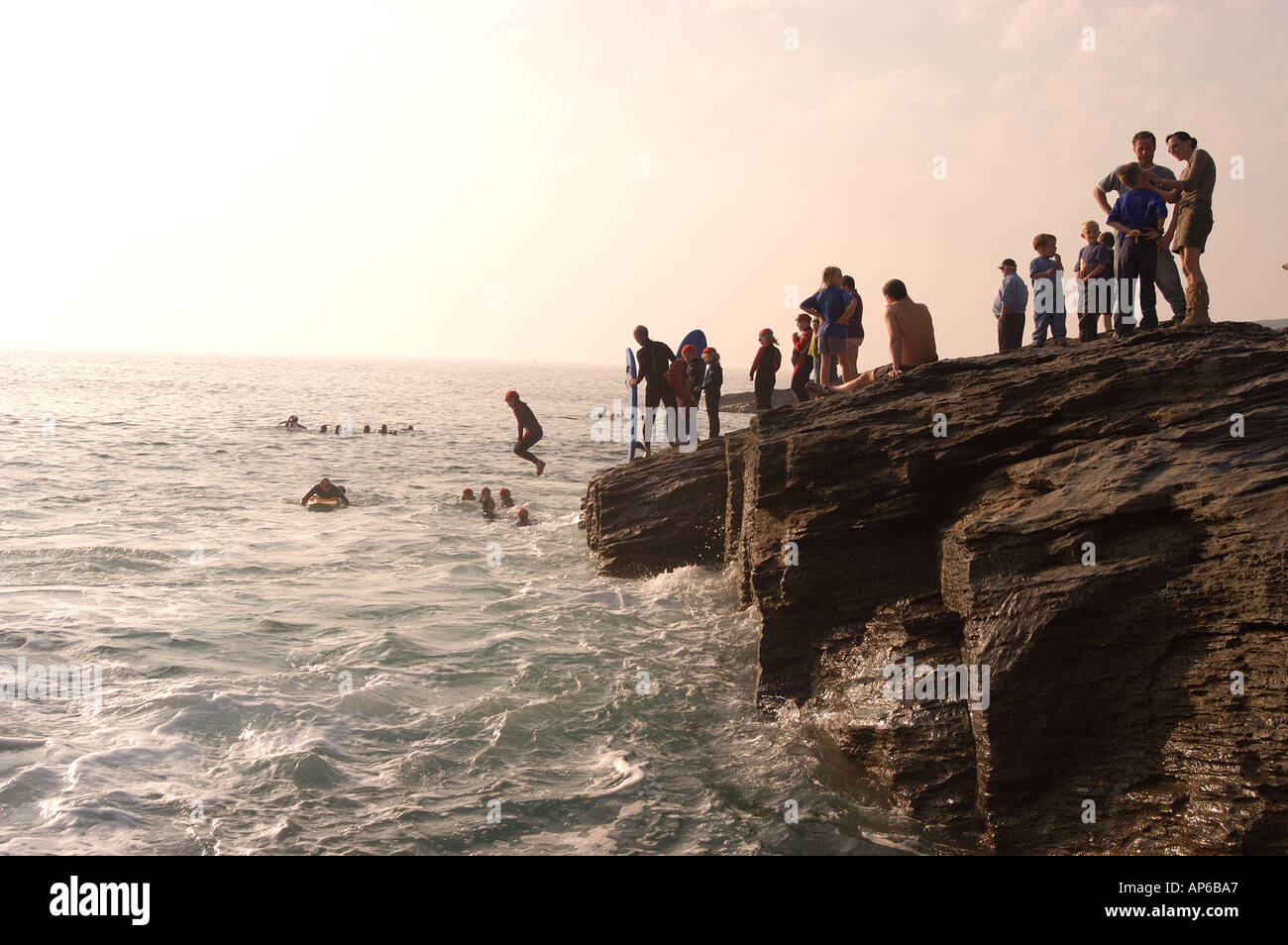 boy jumping off rock at Trebarwith surf school Stock Photo - Alamy
