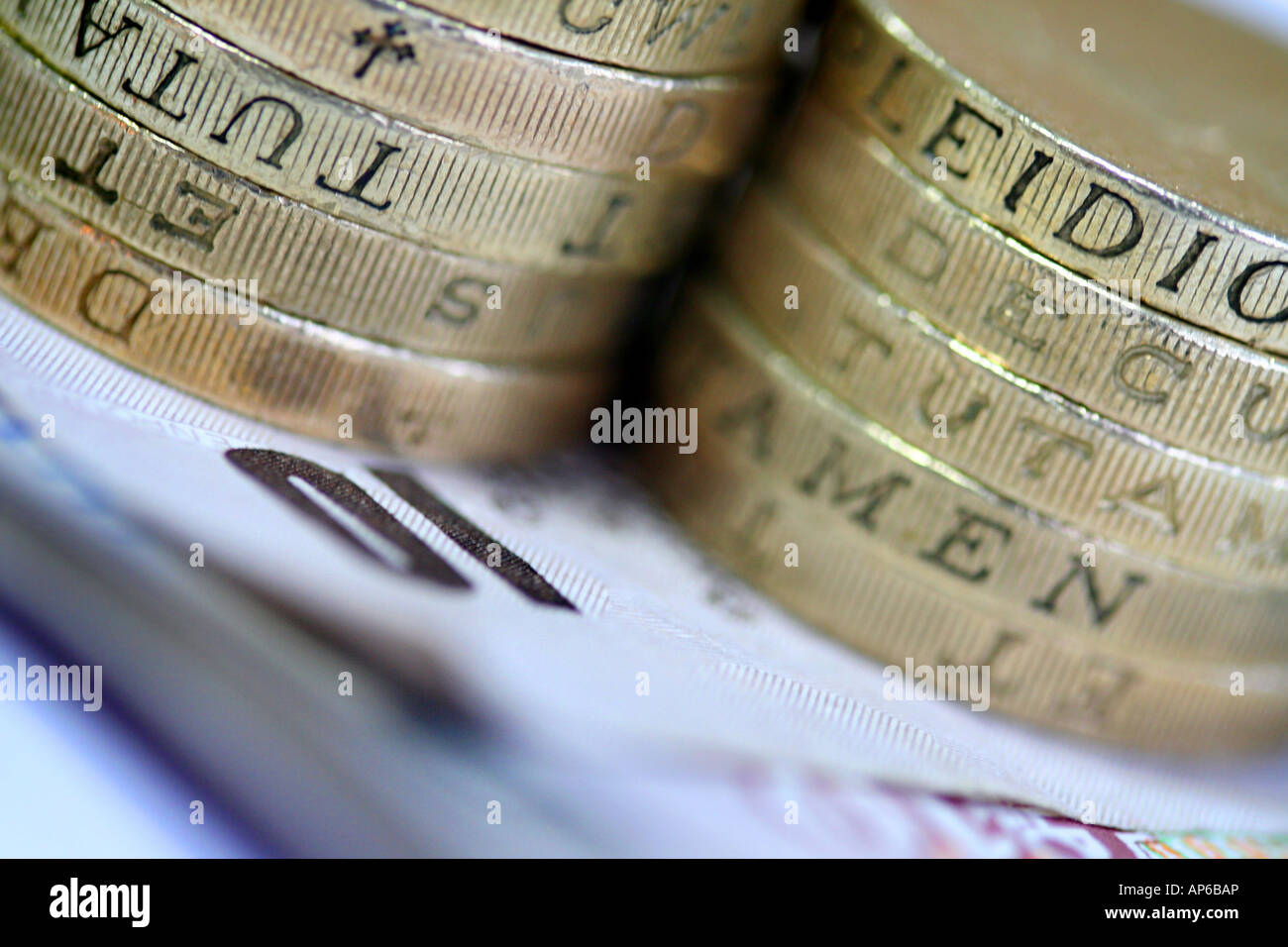 two stacks of british sterling pound coins with ten pound notes Stock ...